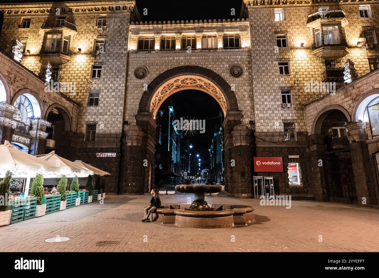 A large archway with a fountain in the middle of a plaza. The fountain ...