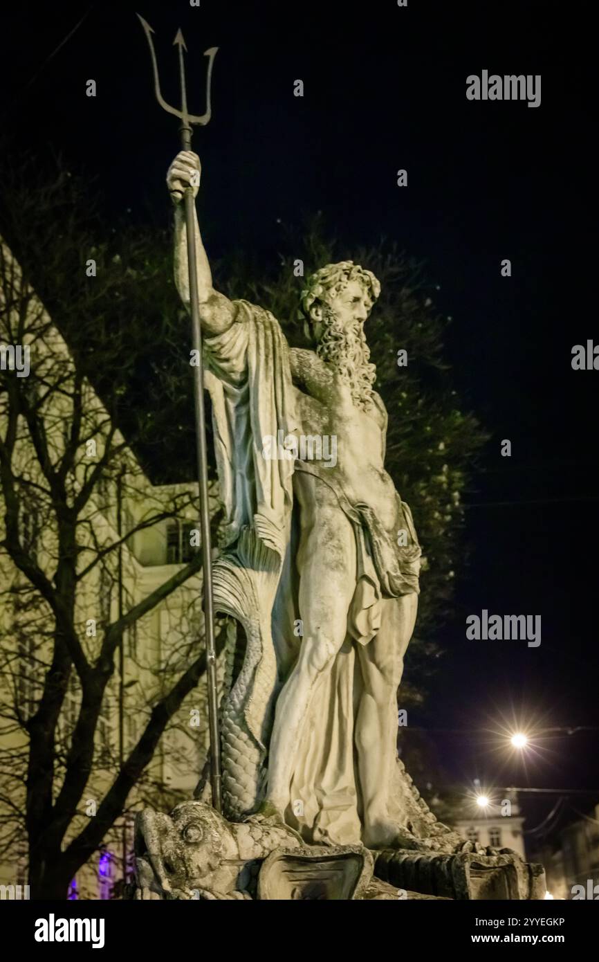 A statue of a man holding a trident is standing in front of a building ...