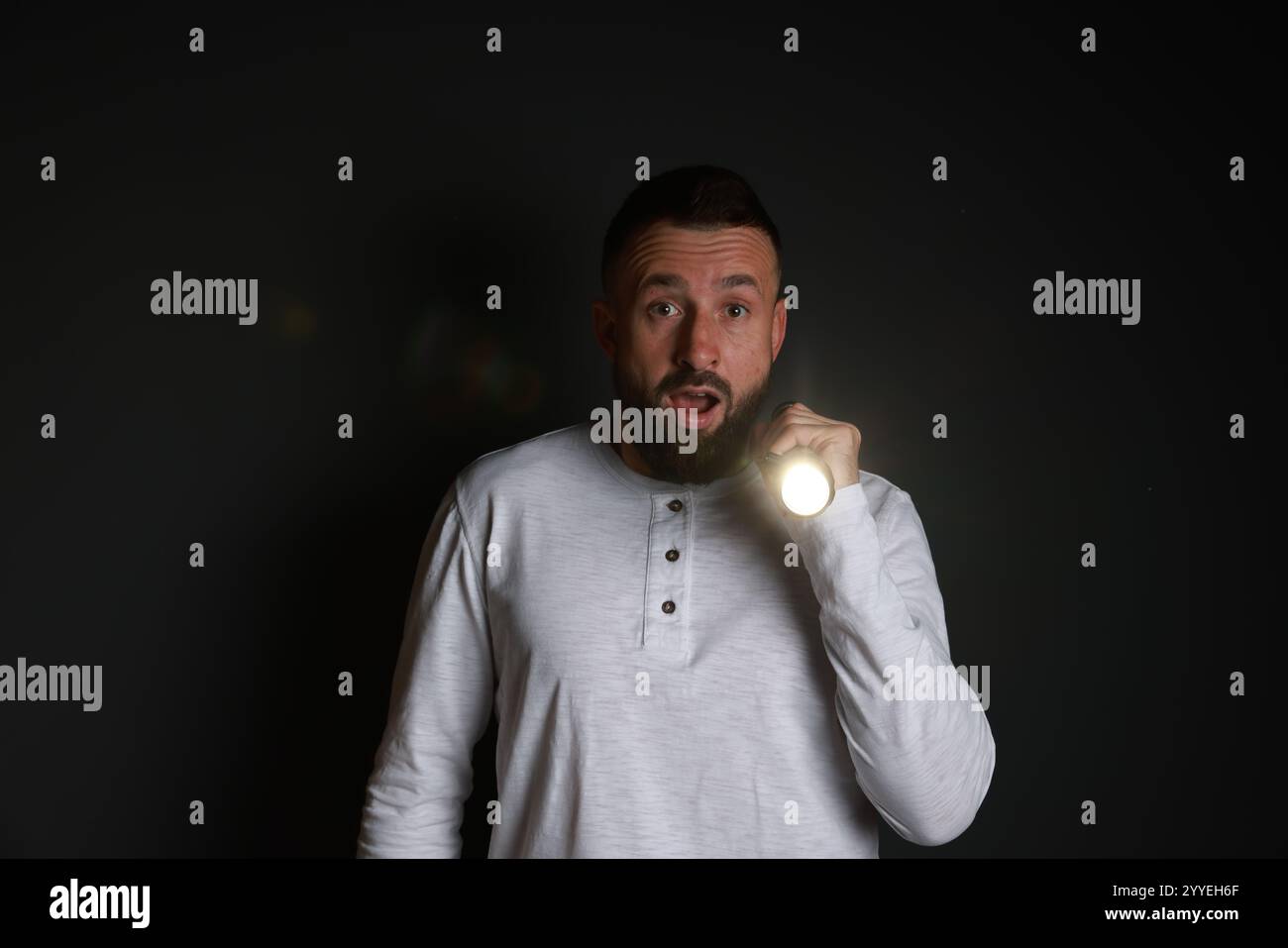 Fear of darkness. Scared man with flashlight on black background Stock ...