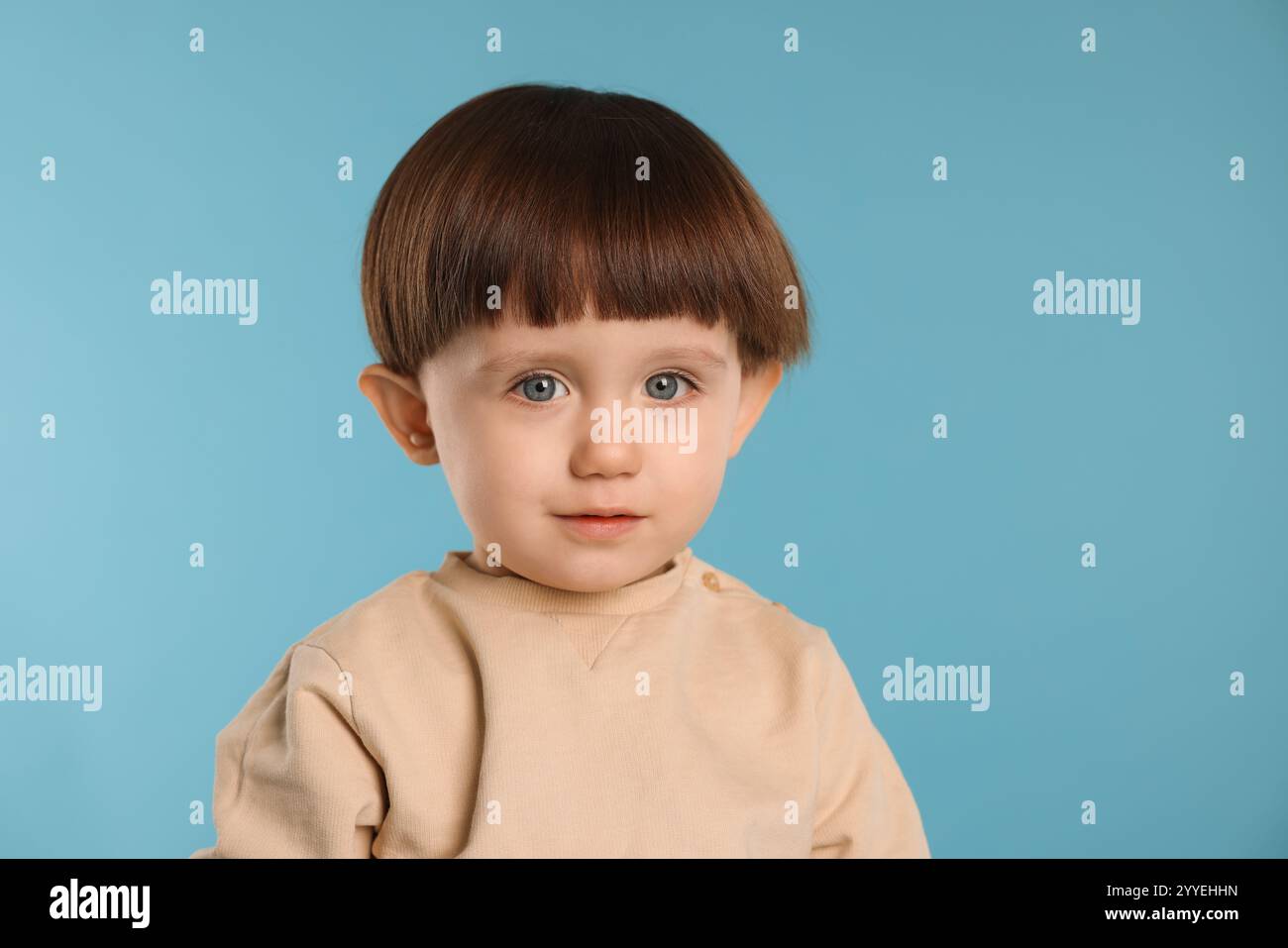 Portrait of cute little boy on light blue background Stock Photo - Alamy