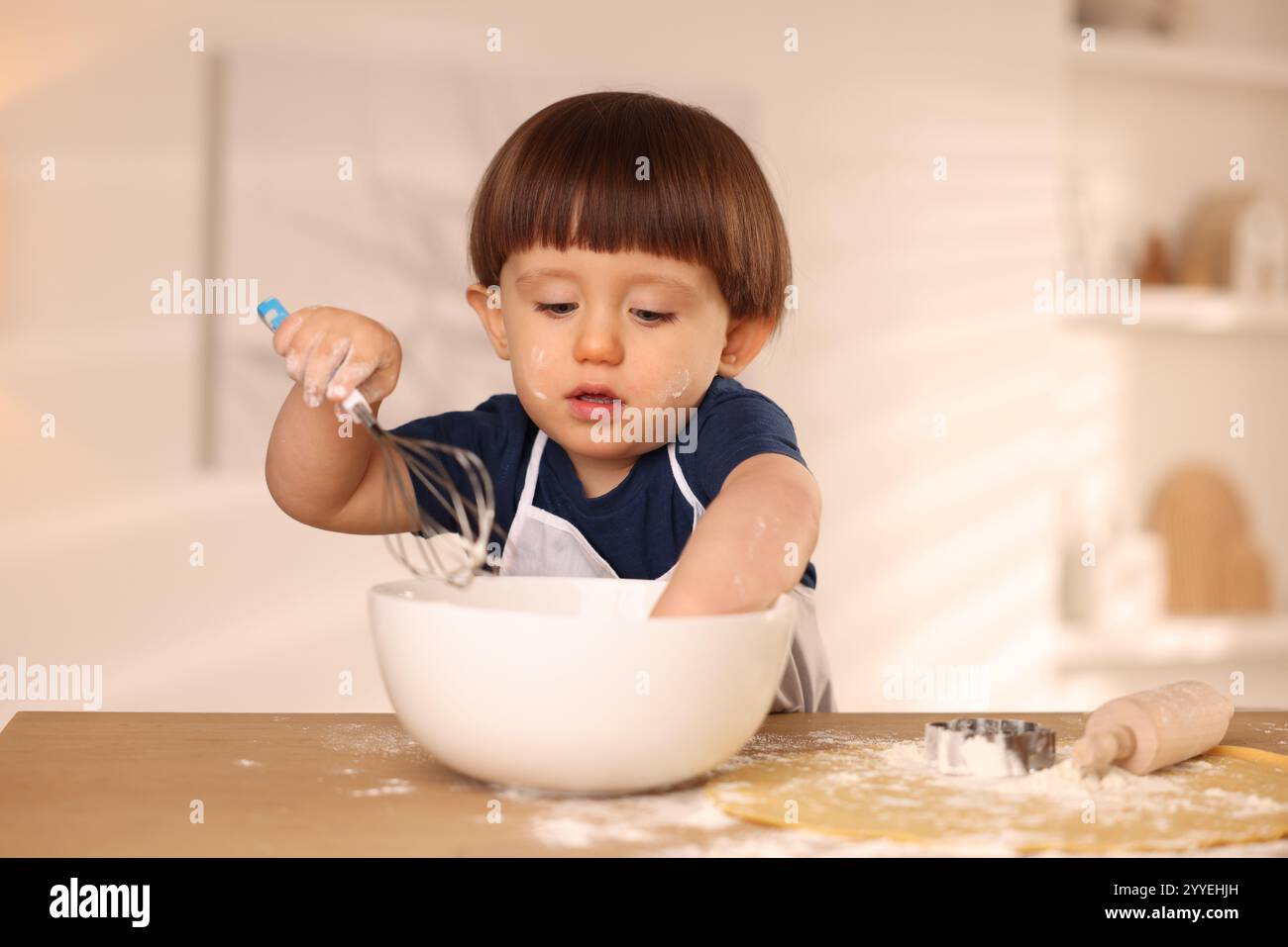 Cute little boy making dough at table indoors Stock Photo - Alamy
