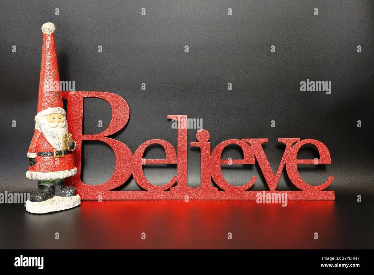 The word Believe next to Santa Clause with a clean seamless black ...