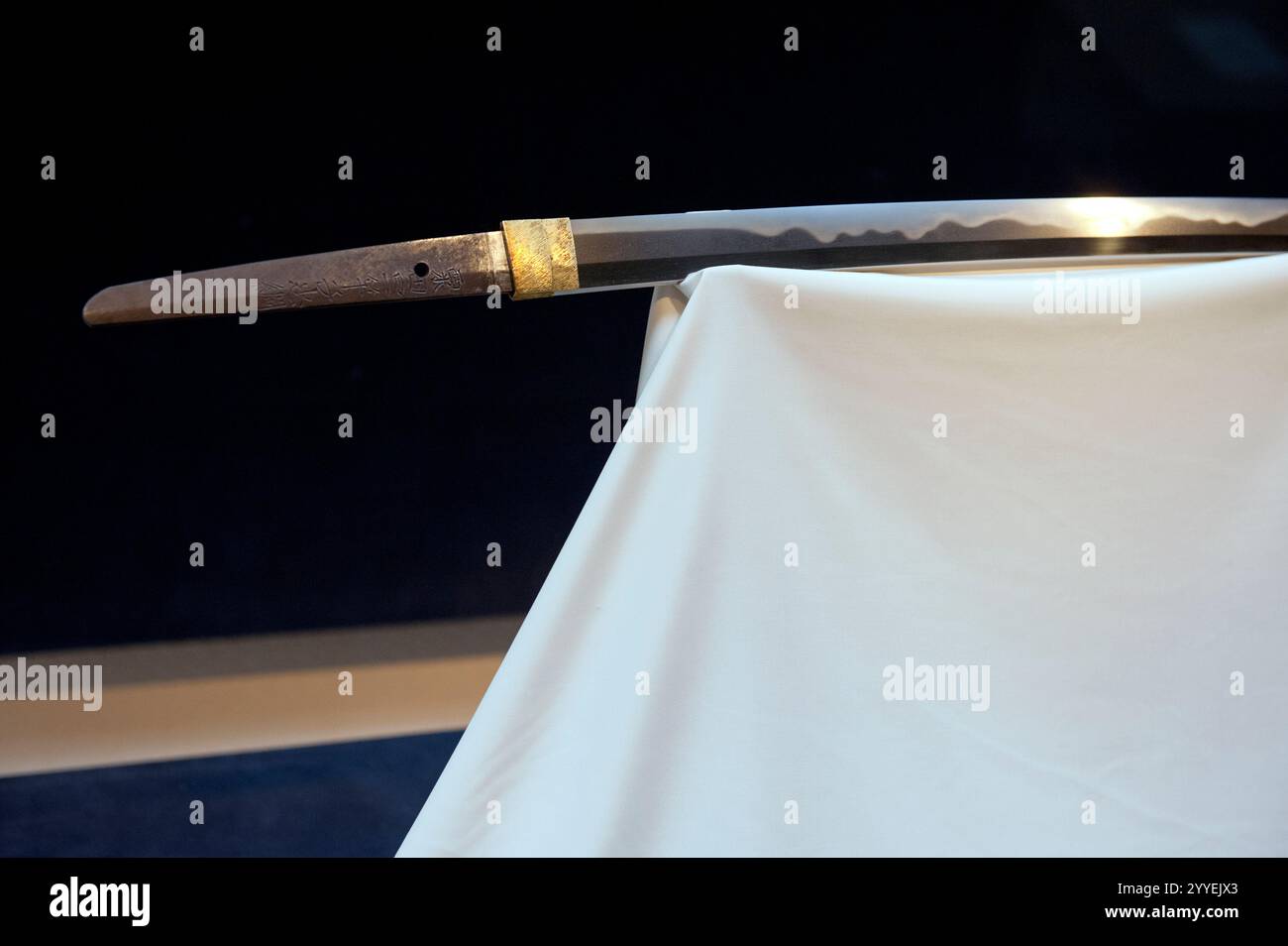 An historic hand-crafted blade of a samurai sword sits in a display ...