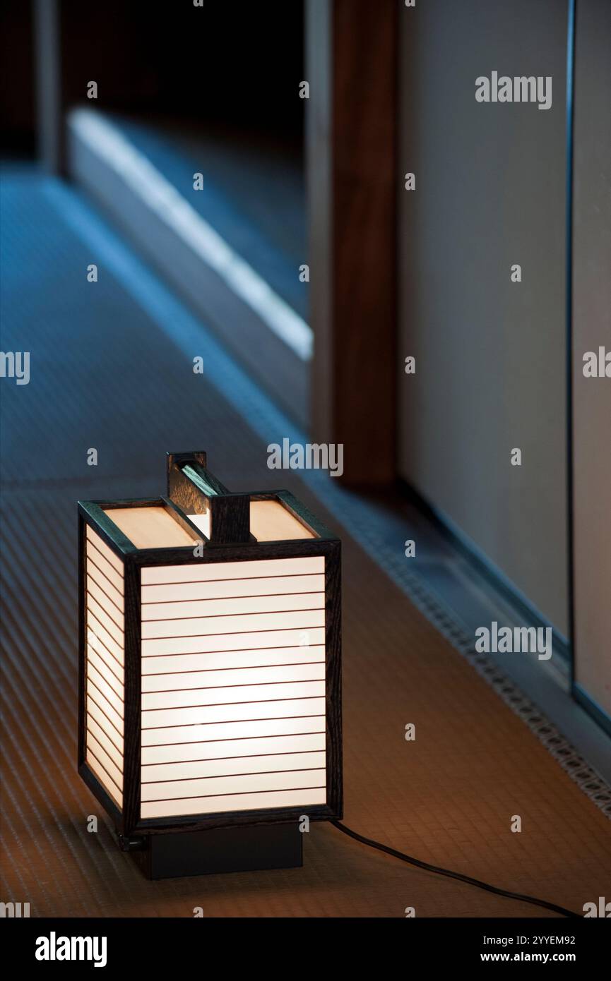 Washi paper and wood frame floor lantern casts a gentle glow in a ...
