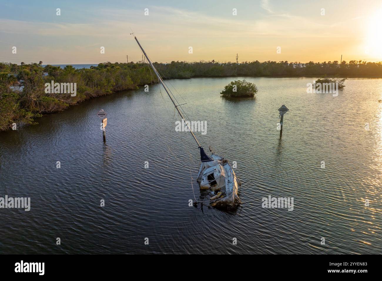 Aerial view of sunken sailboat on shallow bay waters after hurricane in ...
