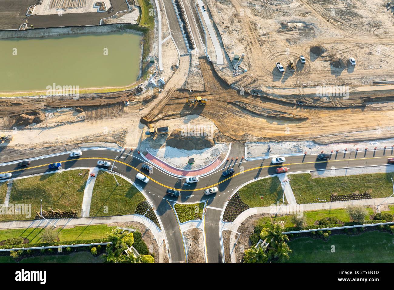 Driving traffic cars at roundabout intersection under construction ...