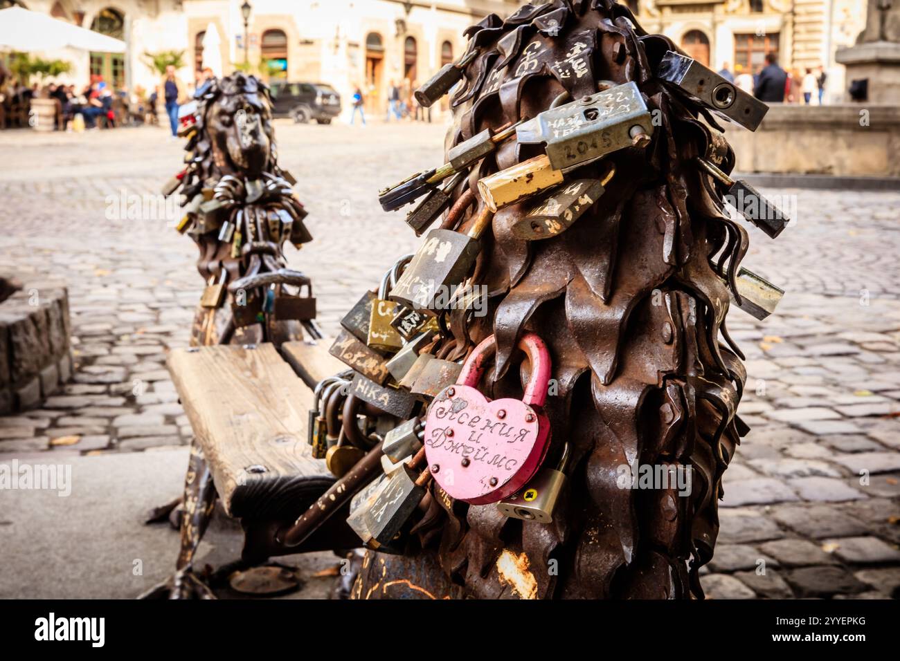 A bench with a lock on it with a red heart on it. The bench is empty ...