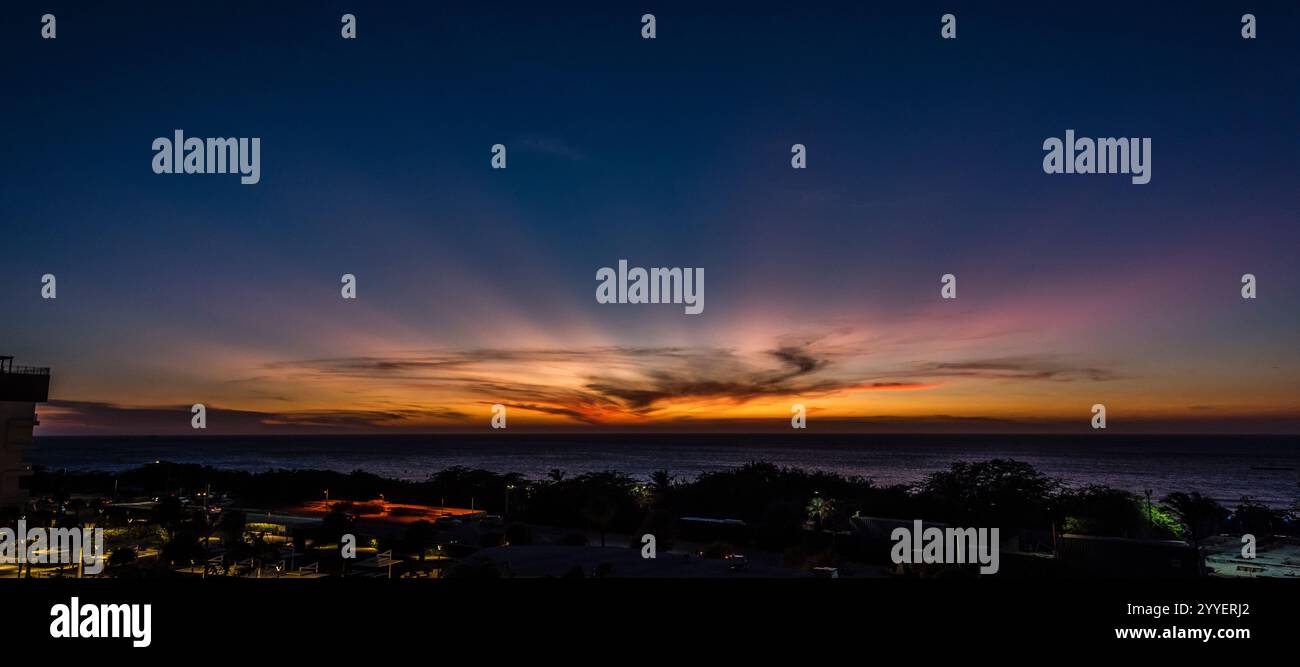 Colorful, panoramic summer sunset on the coast of Aruba, with rays of ...