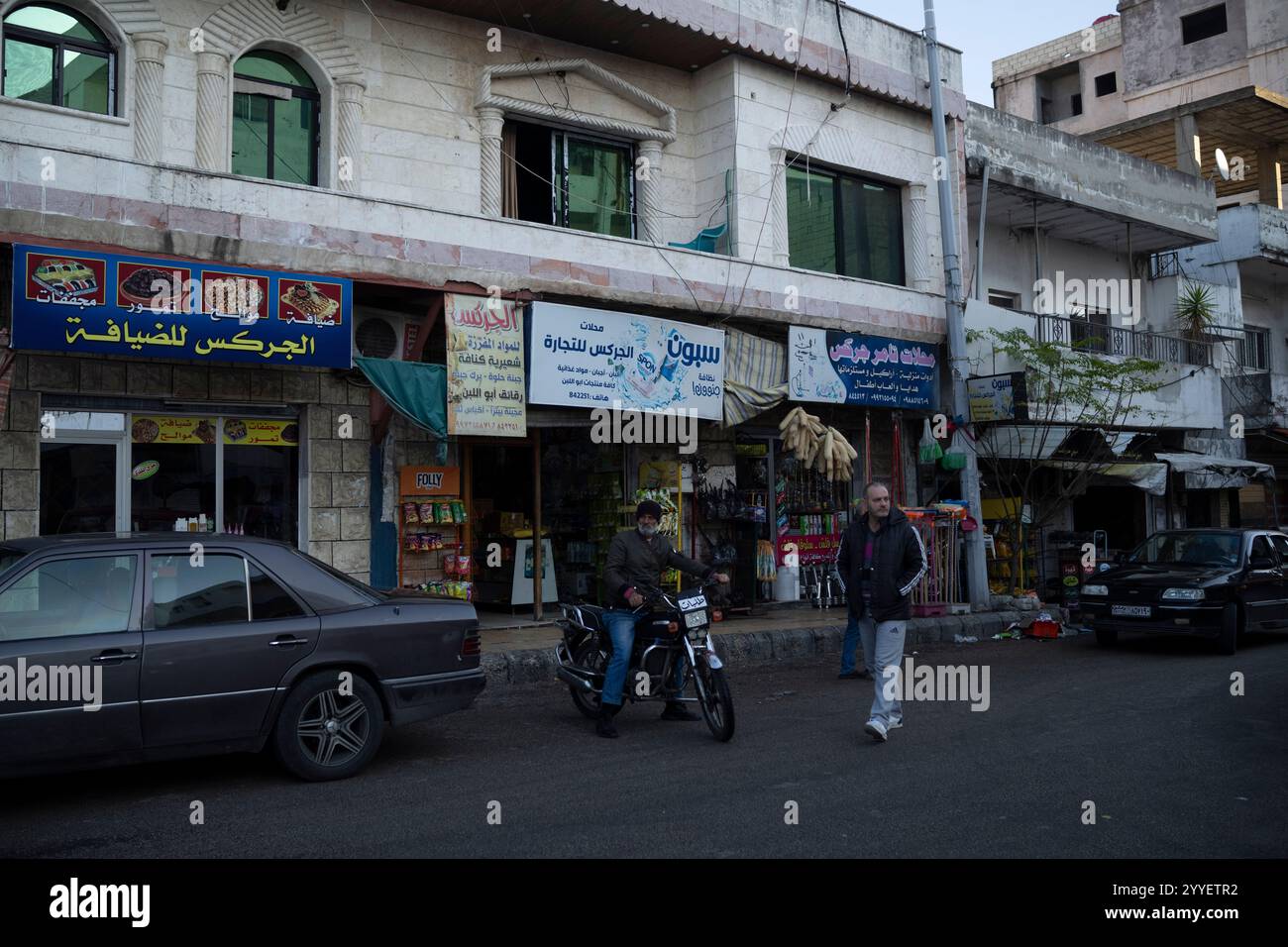 A man walks along the street in Qardaha, Syria, the hometown of late ...