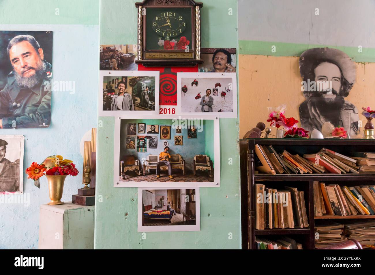Cuba, Havana. House interior wall, bookshelf, posters of National heros ...