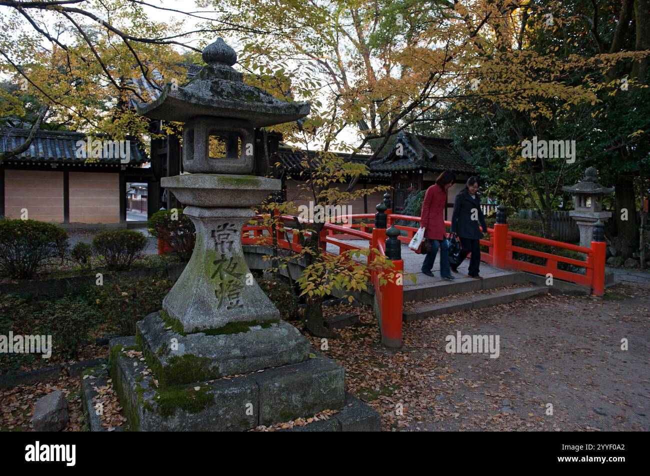 Two women leaving Imamiya Jinja Shinto shrine over the Shinkyo Divine ...