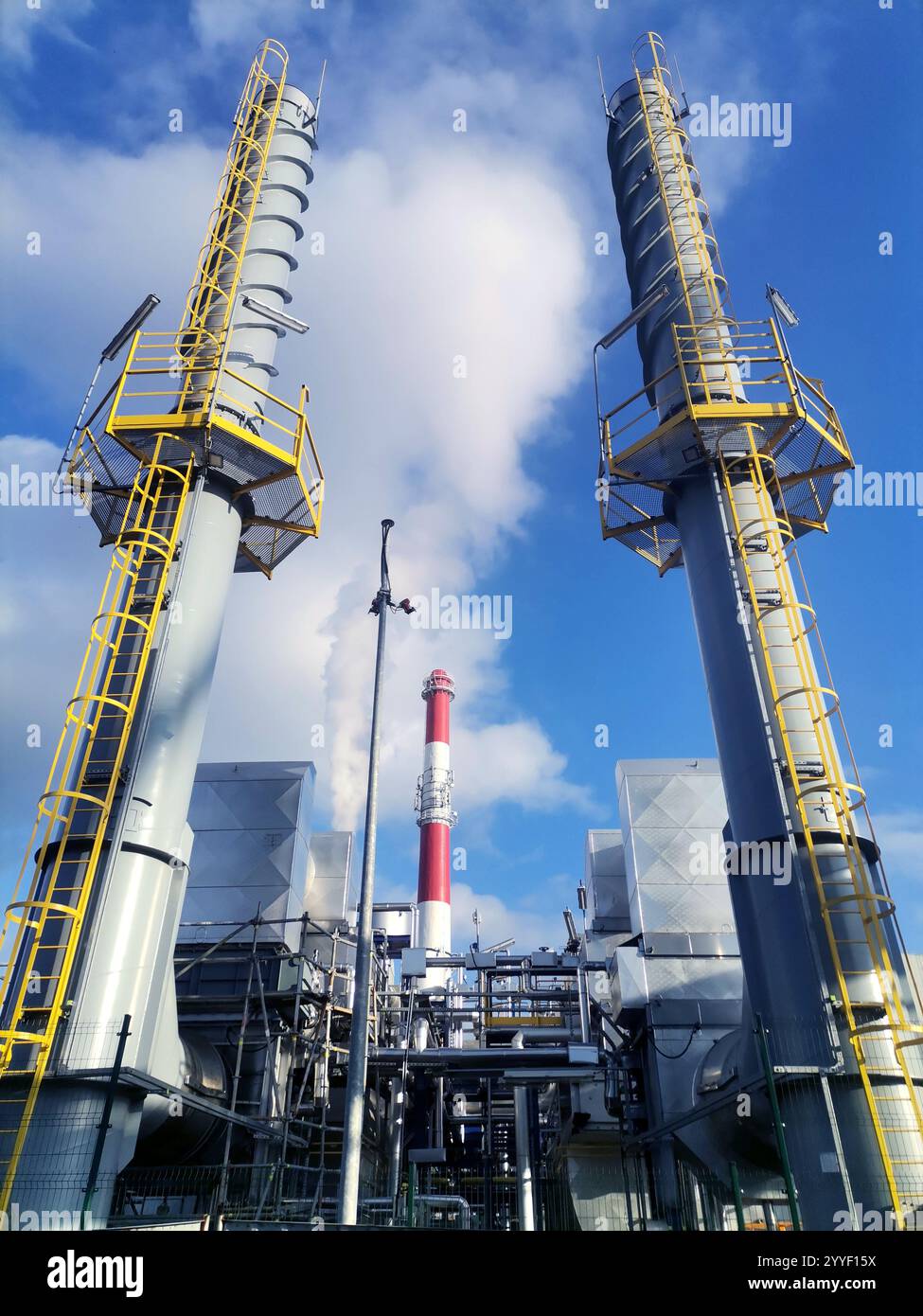 A large factory with thick smoke billowing out from its tall chimneys ...