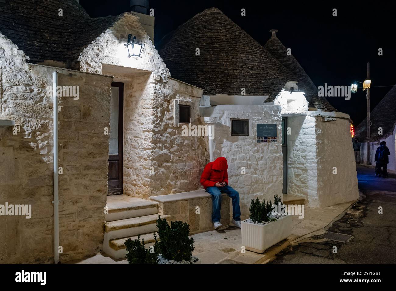 A man sits in front of a trullo during the Life Alberobello Light ...