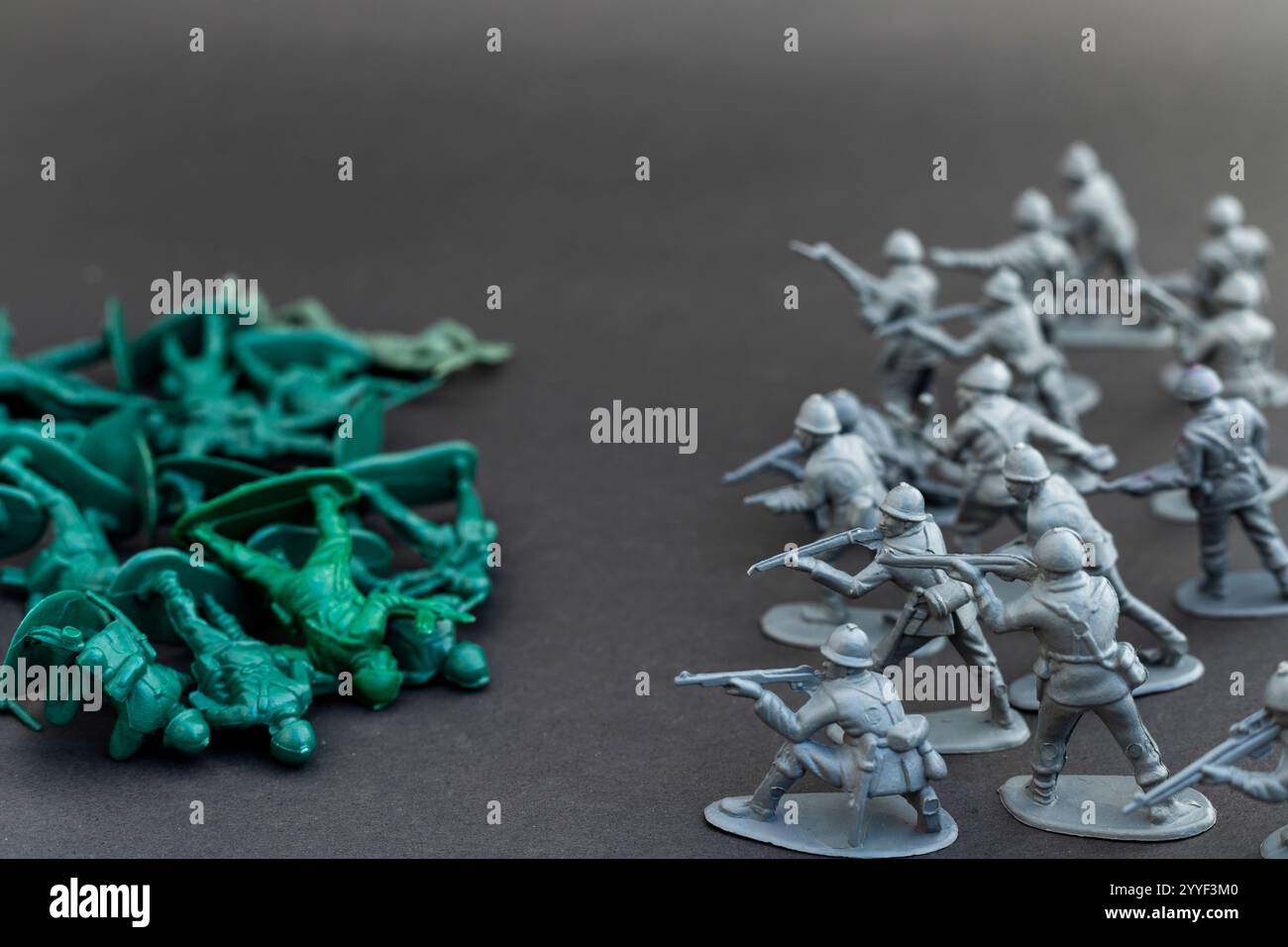 Fallen green toy soldiers facing gray troops on a battlefield diorama ...