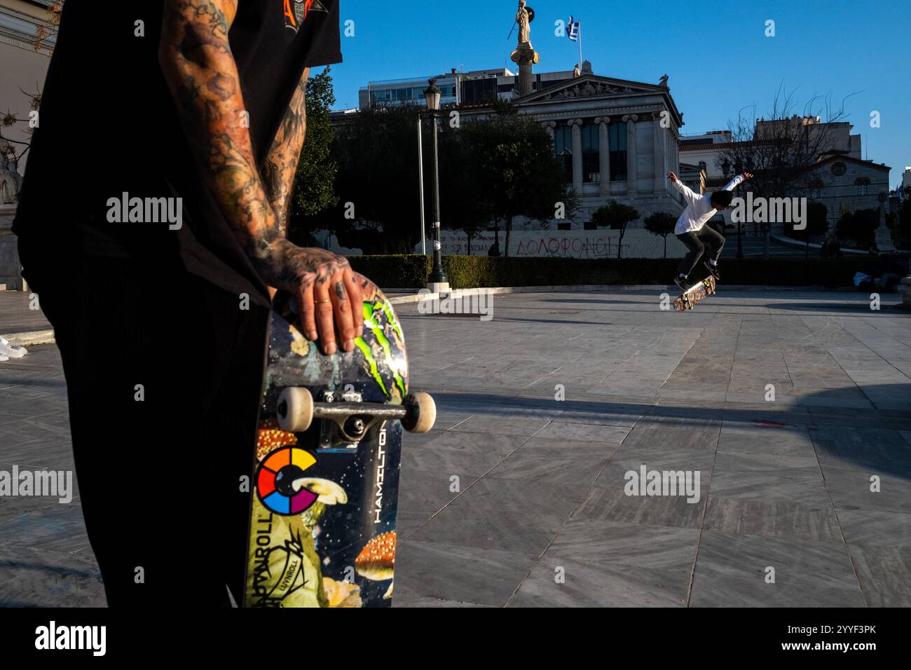 Young Greek boy skateboarding on the square in front of the National ...