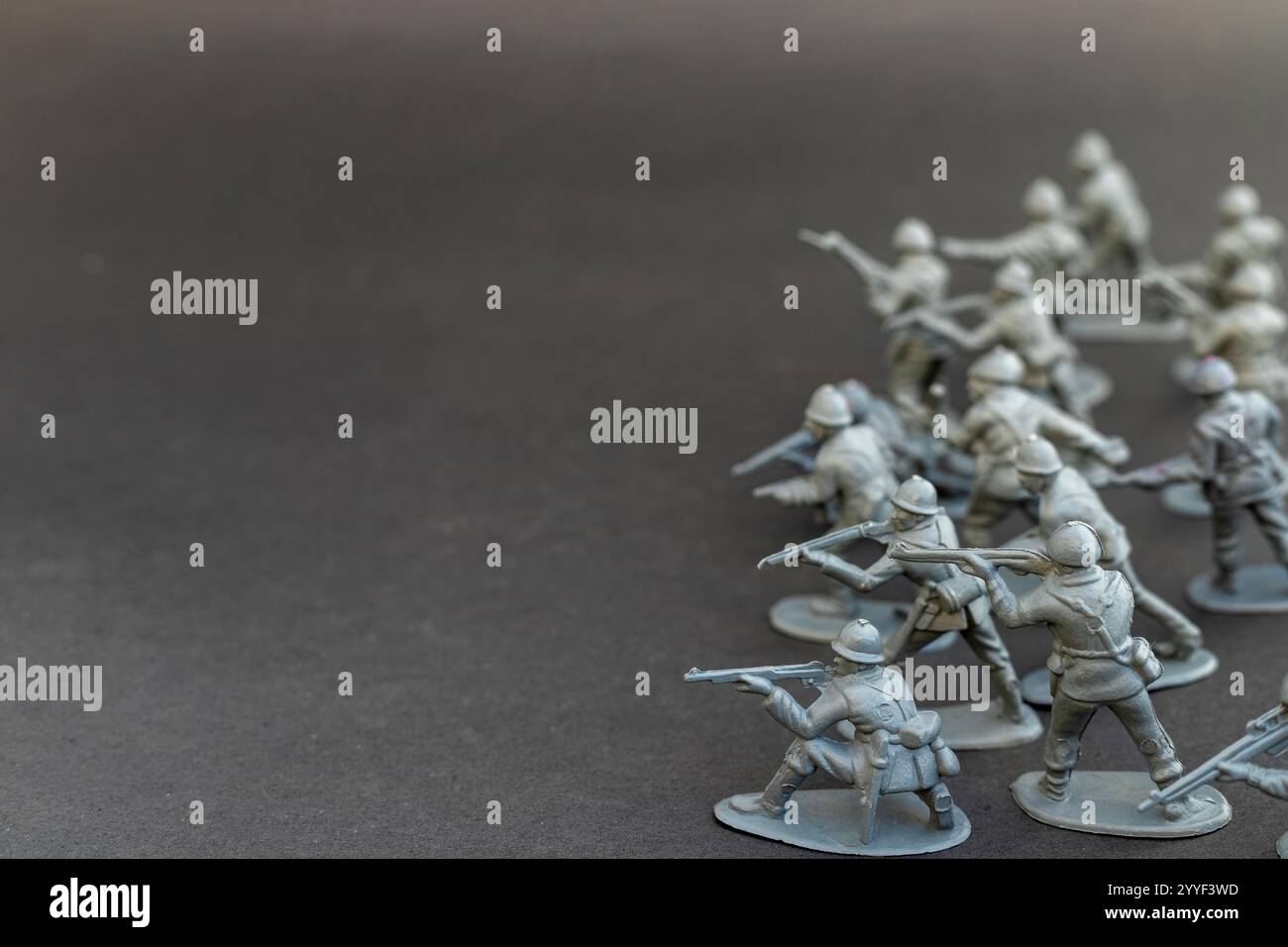 Group of gray toy soldiers in battle stance on dark background Stock ...