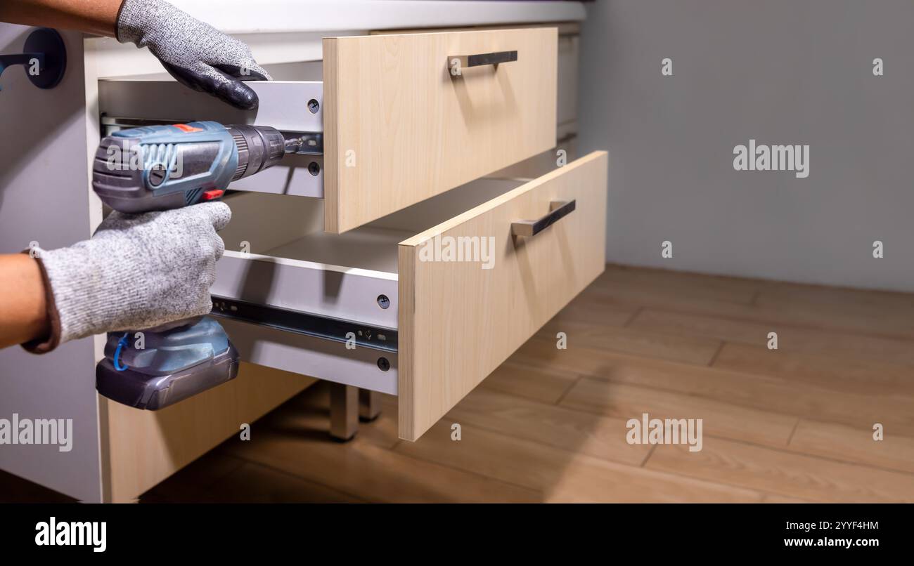 Worker fix over tight drawer slides in kitchen. Concept Fix stuck ...