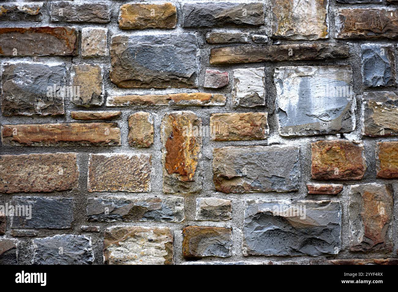 A close-up of a stone wall, constructed from irregularly shaped stones ...
