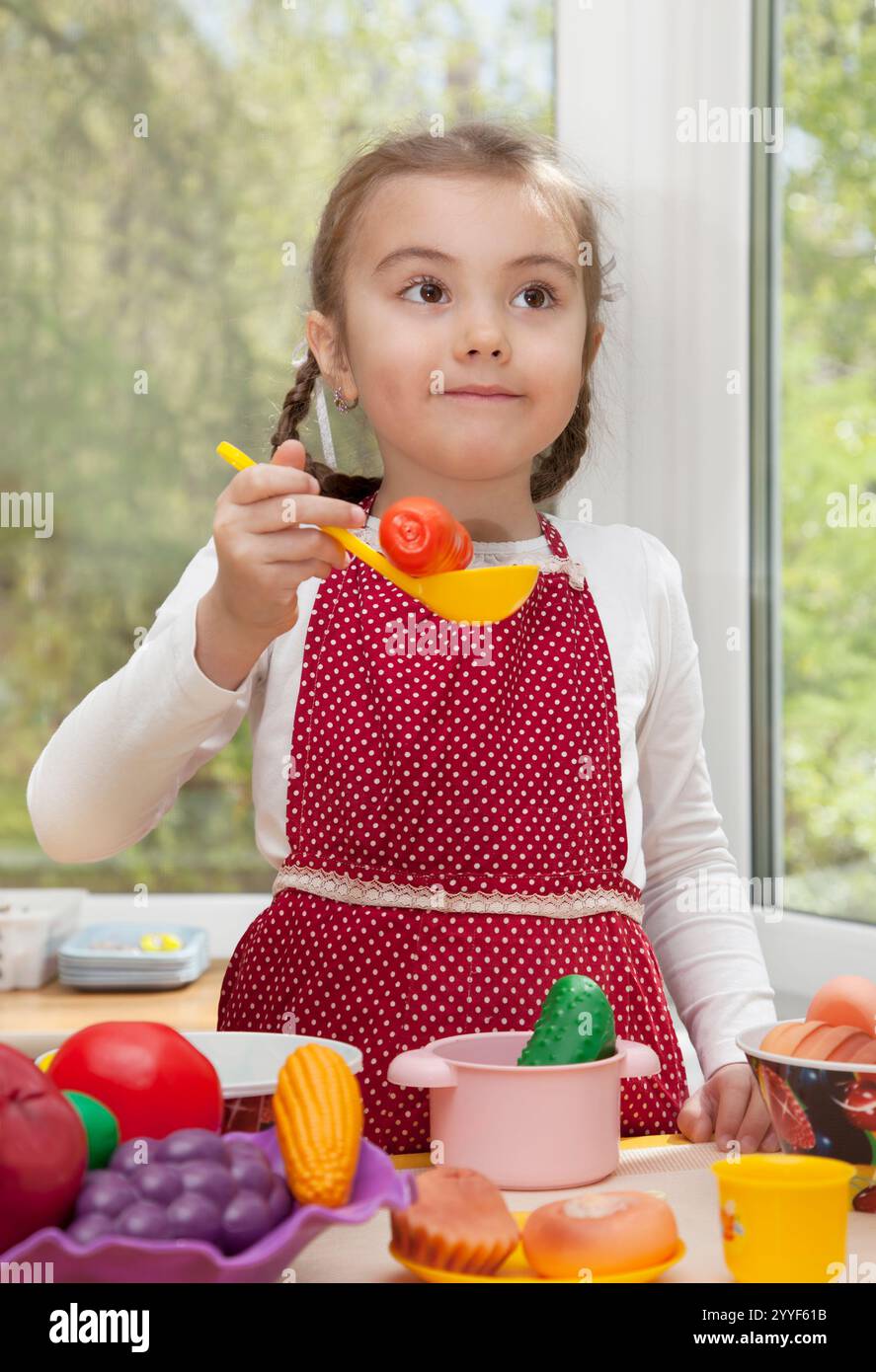 Happy little girl play cooking in her play kitchen Stock Photo - Alamy
