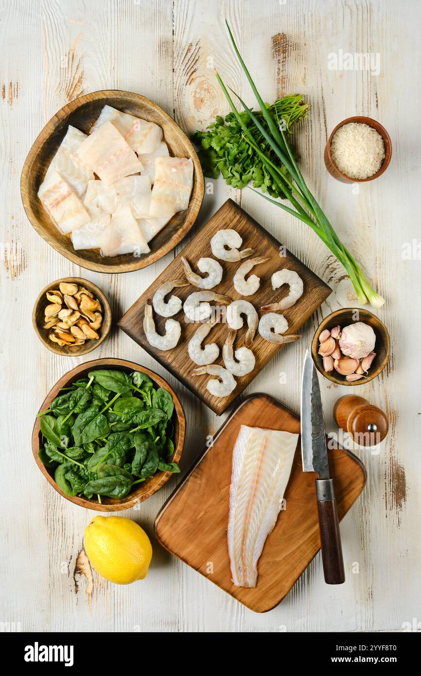 The kitchen countertop displays an assortment of fresh seafood and ...