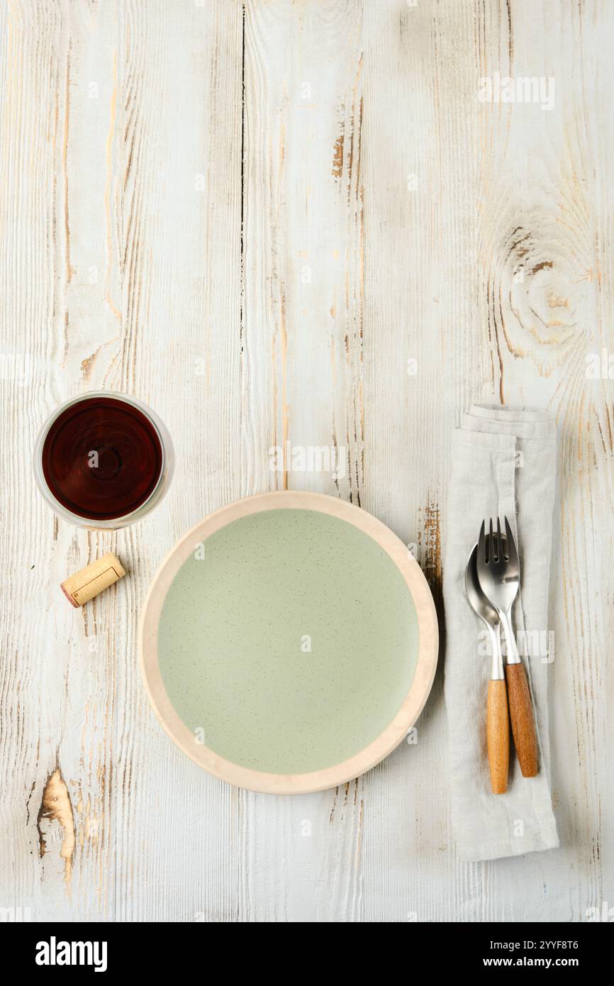 A minimalistic dining arrangement showcases a pale green plate next to ...