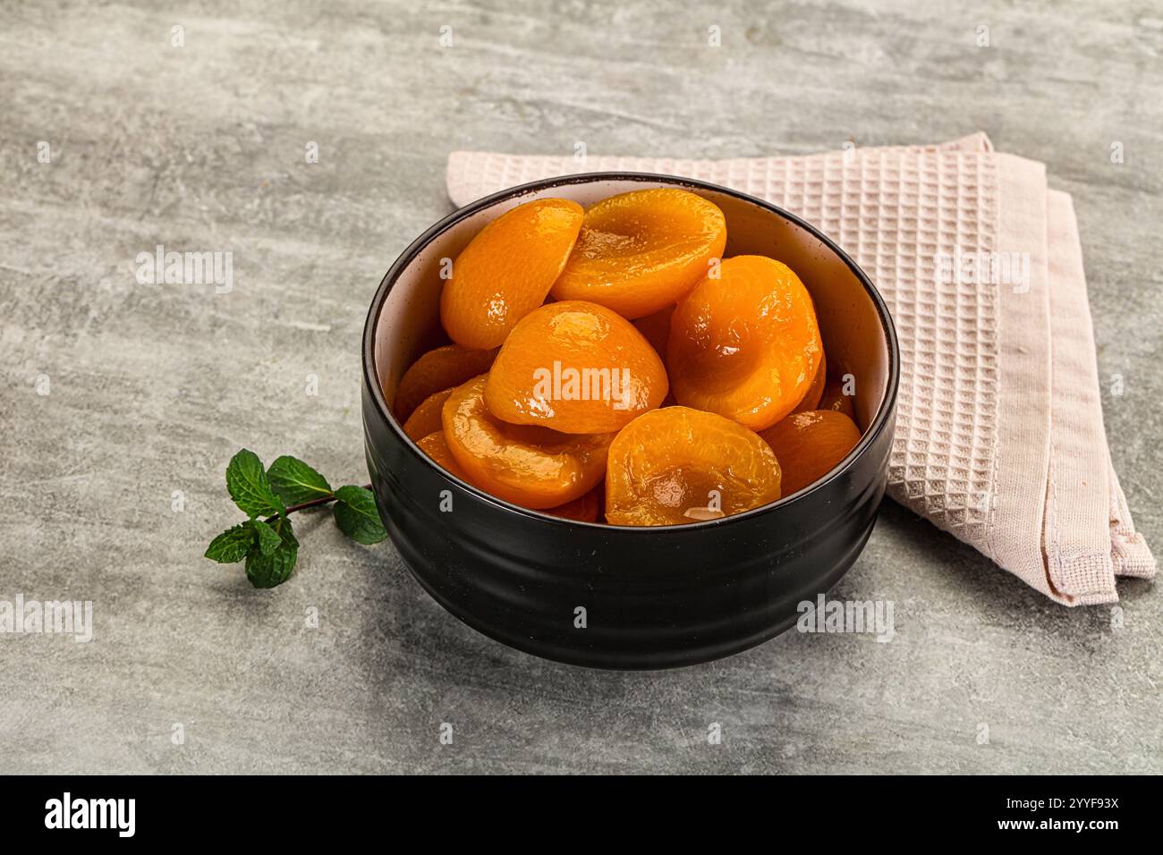Sweet canned apricots with syrope in the bowl Stock Photo - Alamy