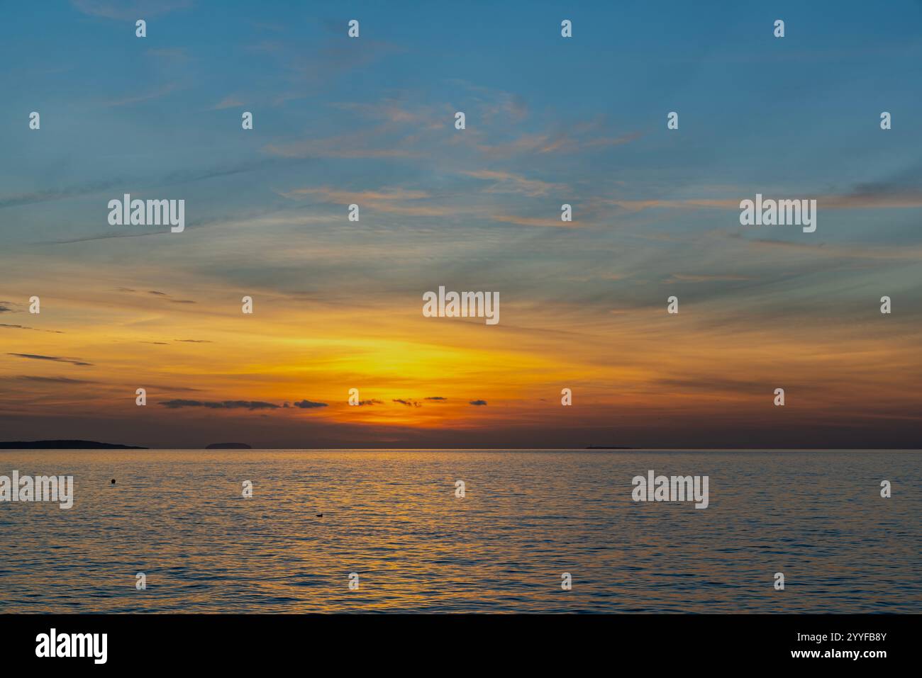 The setting sun lighting up the horizon an orangey reddish hue Stock ...