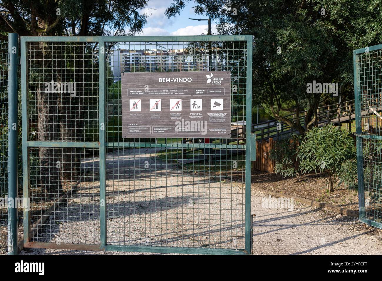 Metal gate with welcome sign and usage rules at the entrance of parque ...