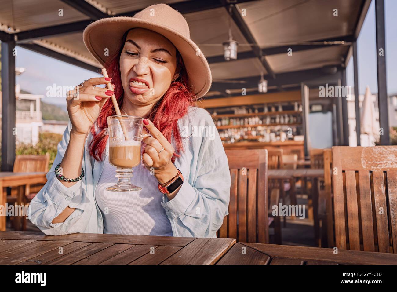 Tourist making a disgusted face while drinking a bad coffee in an ...