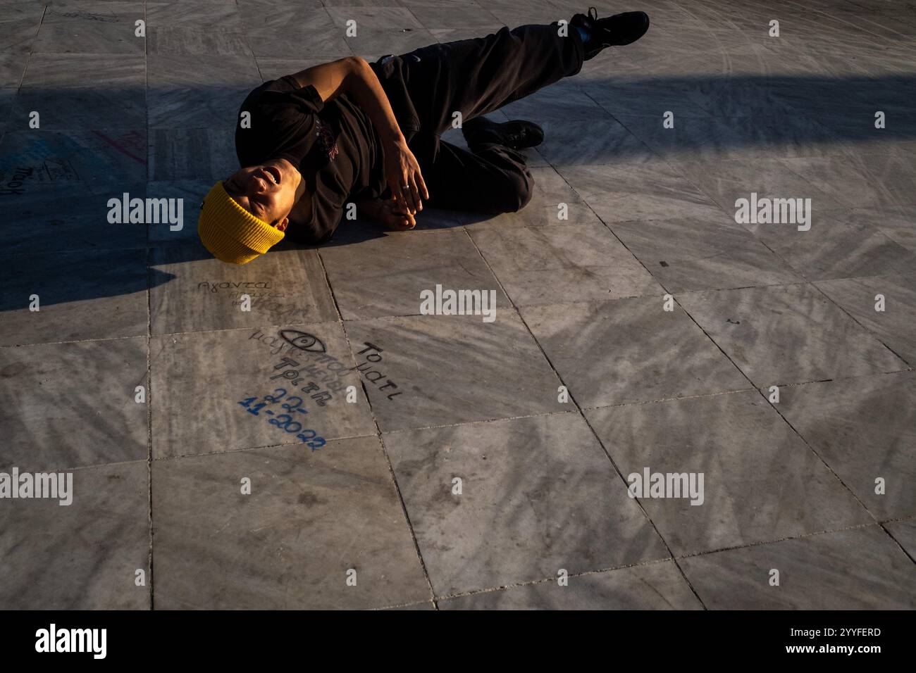 Young Greek boy falls while skateboarding on the square in front of the ...