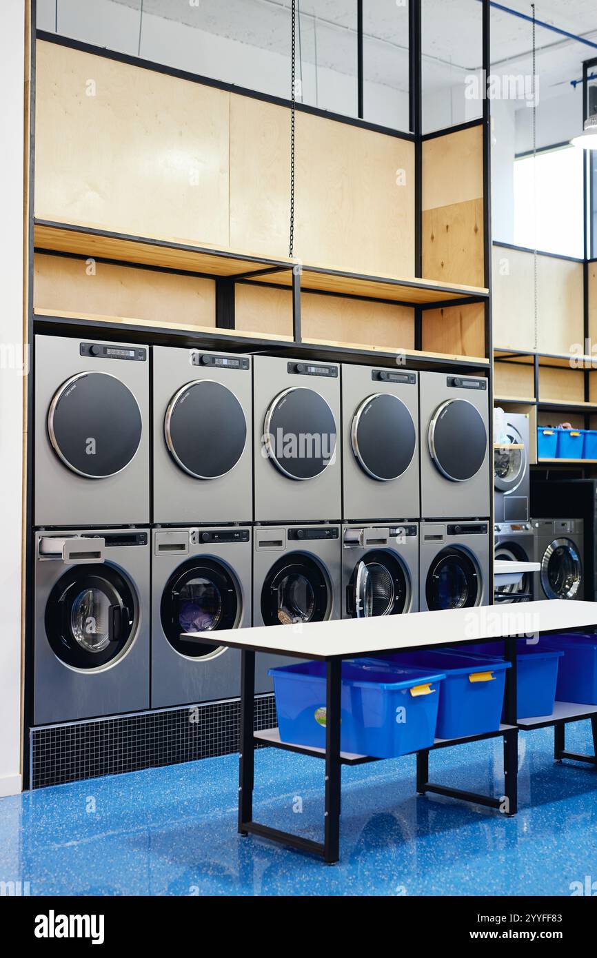 Interior of modern self service laundry featuring double row of ...