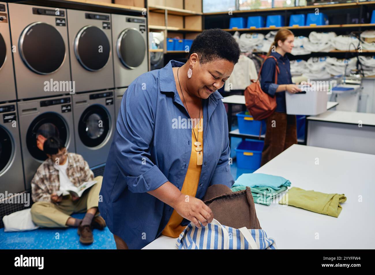 Medium shot of smiling senior African American woman packing clean ...