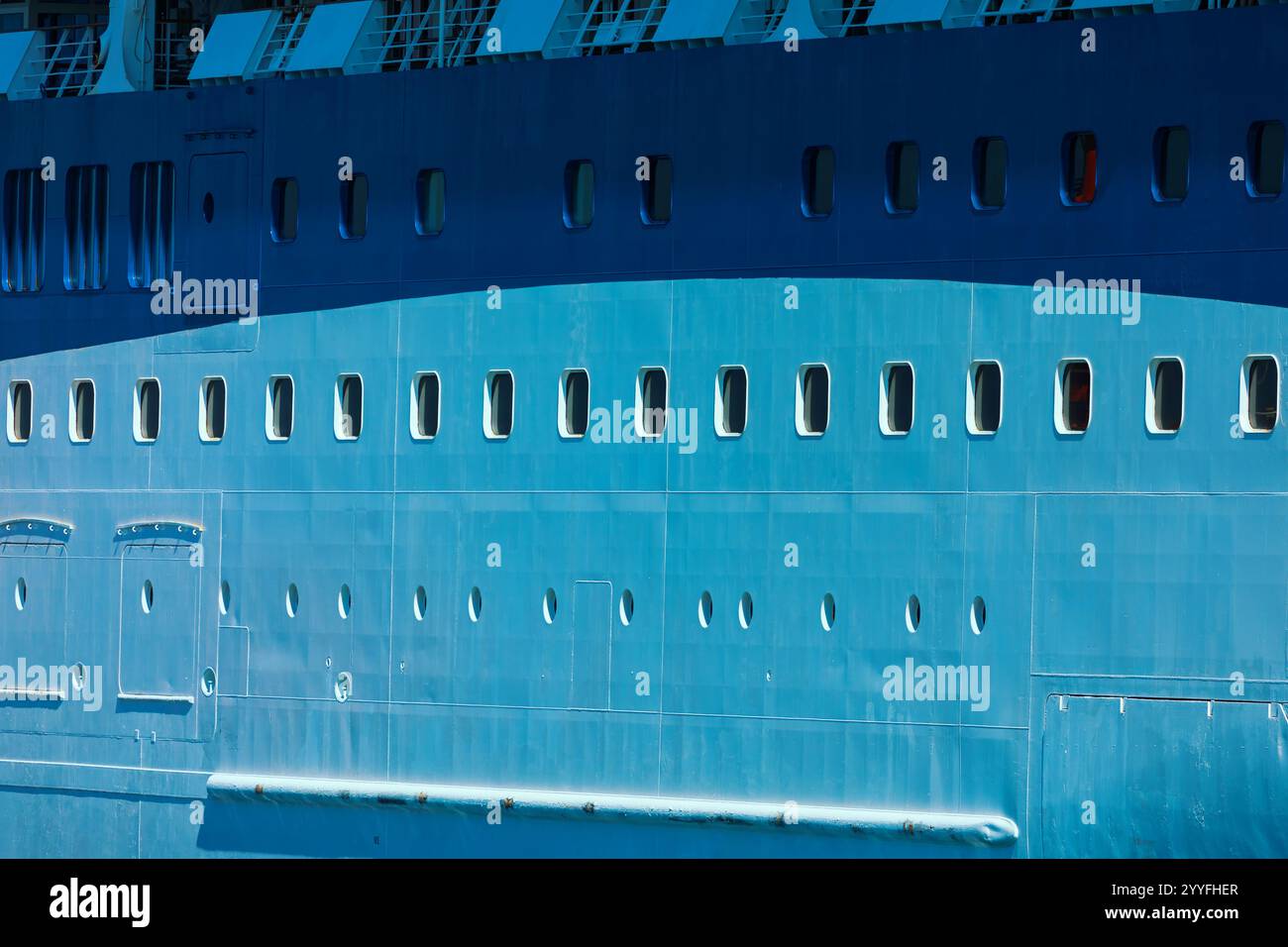Side of large ship, likely a cruise ship or a ferry, with multiple rows ...