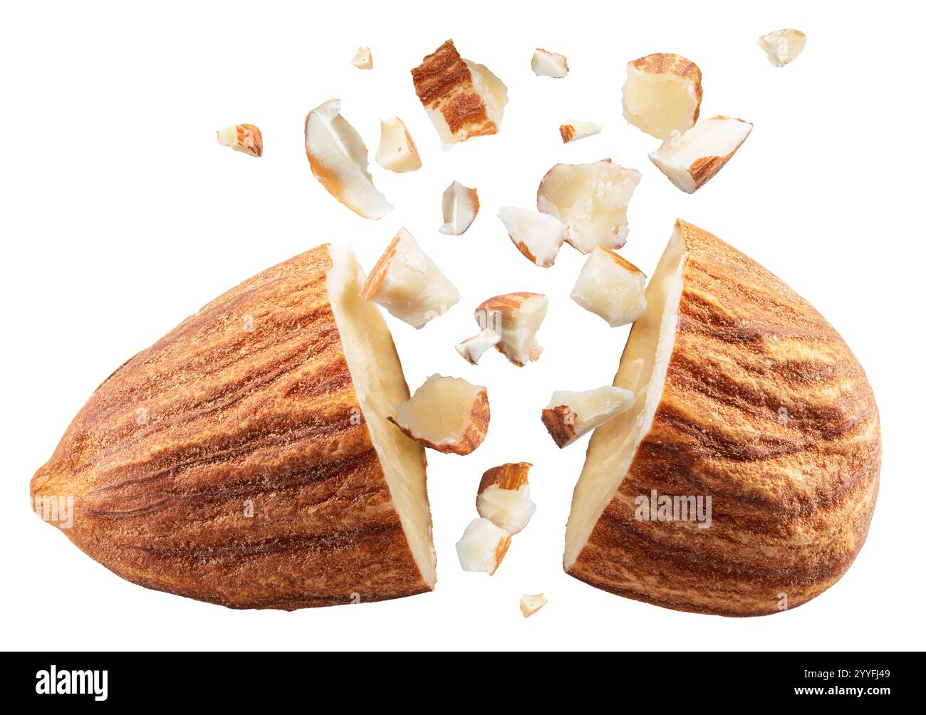 Almond nut split in half, and pieces of almond nut fly out from crack ...