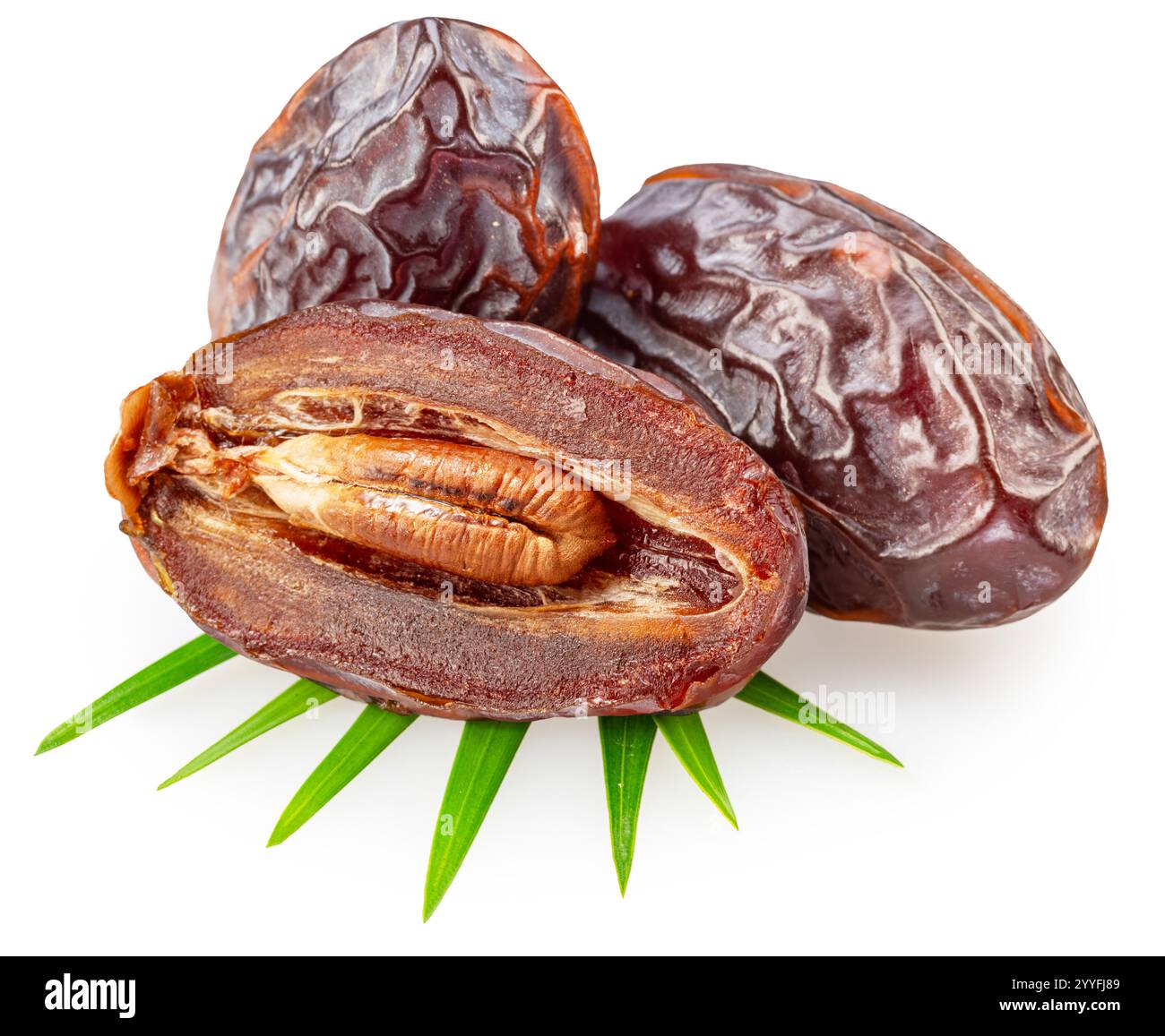 Semi-dried dates and date fruit cut in half lie on palm leaves isolated ...