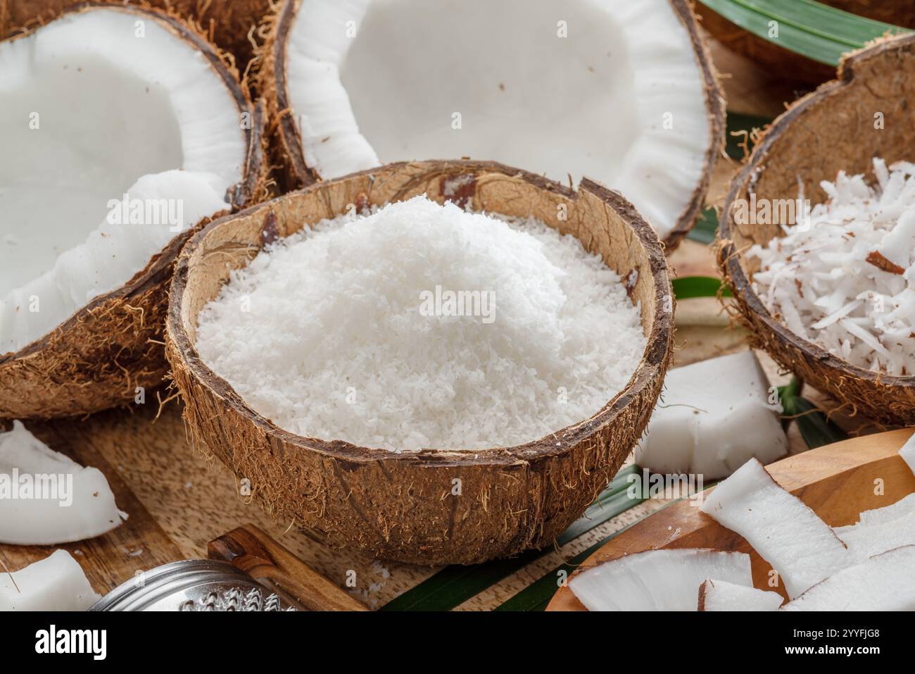 Fresh opened coconuts along with coconut slices, flakes and coconut ...