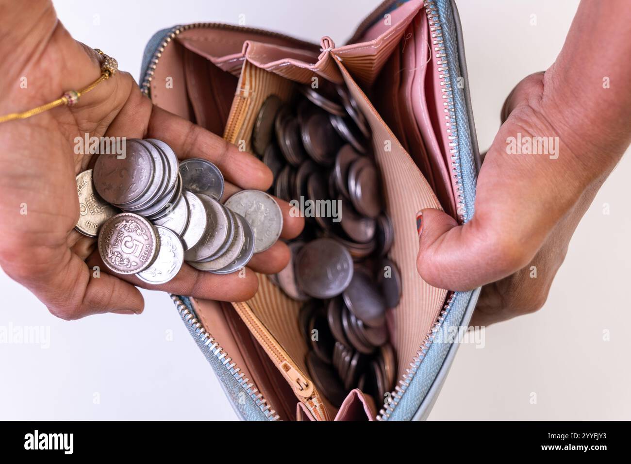 Hands holding a purse full of Indian rupee coins, highlighting savings ...