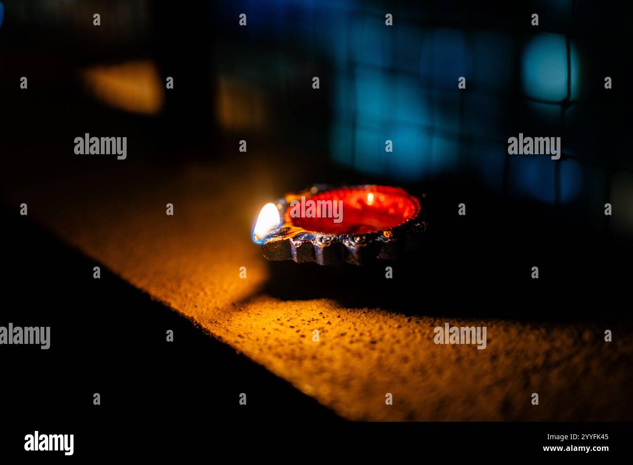 A single diya illuminates the dark, casting a warm glow. A symbol of ...