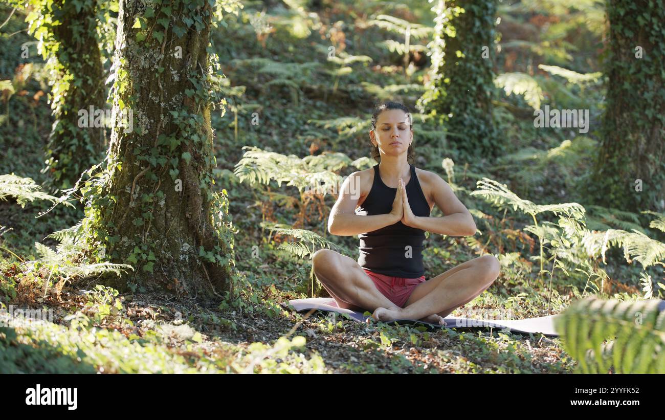 Woman is practicing yoga in nature. Seated gentle easy pose for relief ...
