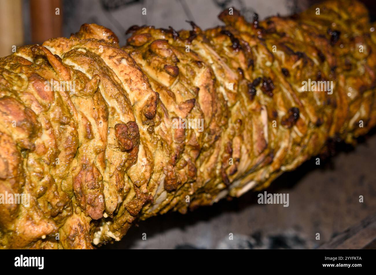 Juicy, marinated chicken shawarma slowly roasting on a vertical ...