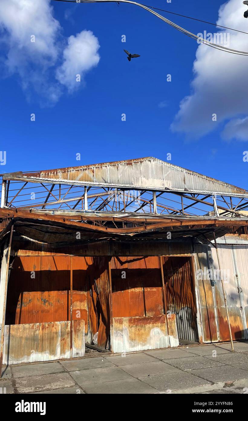 warehouse with a loading ramp after a fire. Burnt metal frame of the ...
