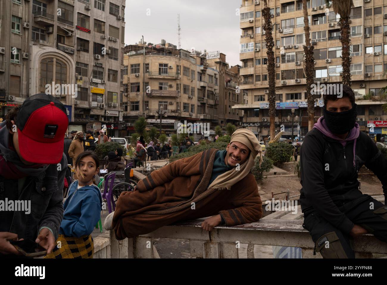 A man smiles as he talks with his friends at the Marjeh square in ...