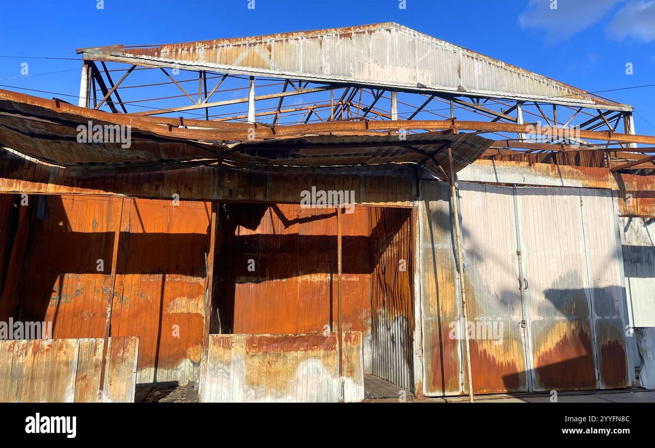 warehouse with a loading ramp after a fire. Burnt metal frame of the ...