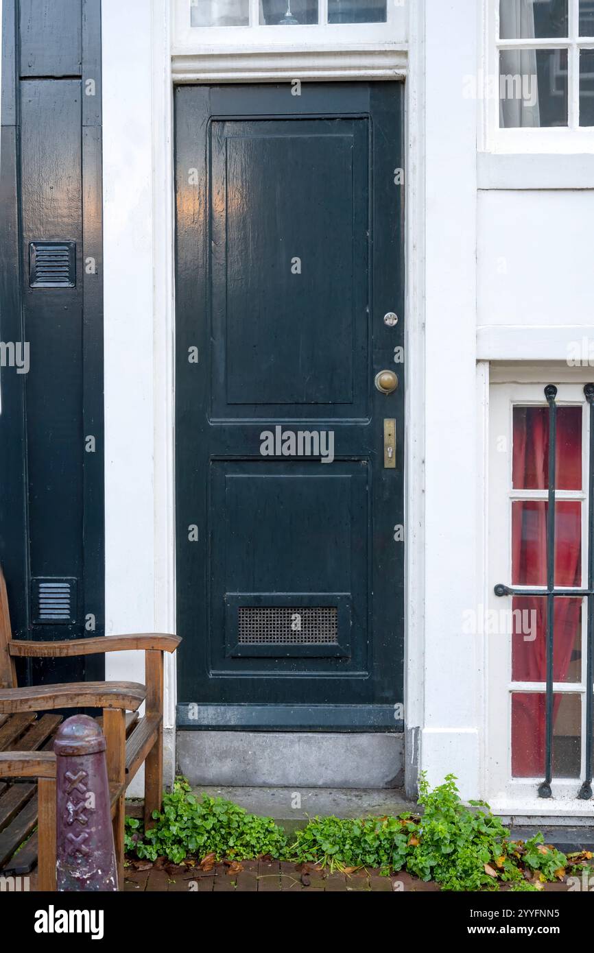 The facade of the house with chair and green front door in Amsterdam ...