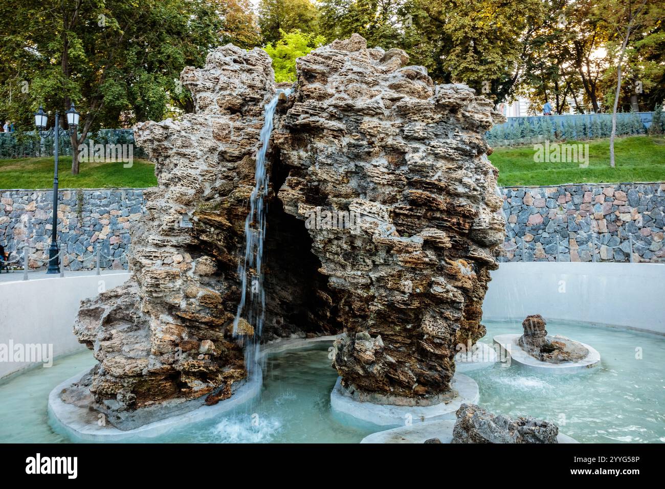 A large rock with a waterfall coming out of it. The waterfall is ...