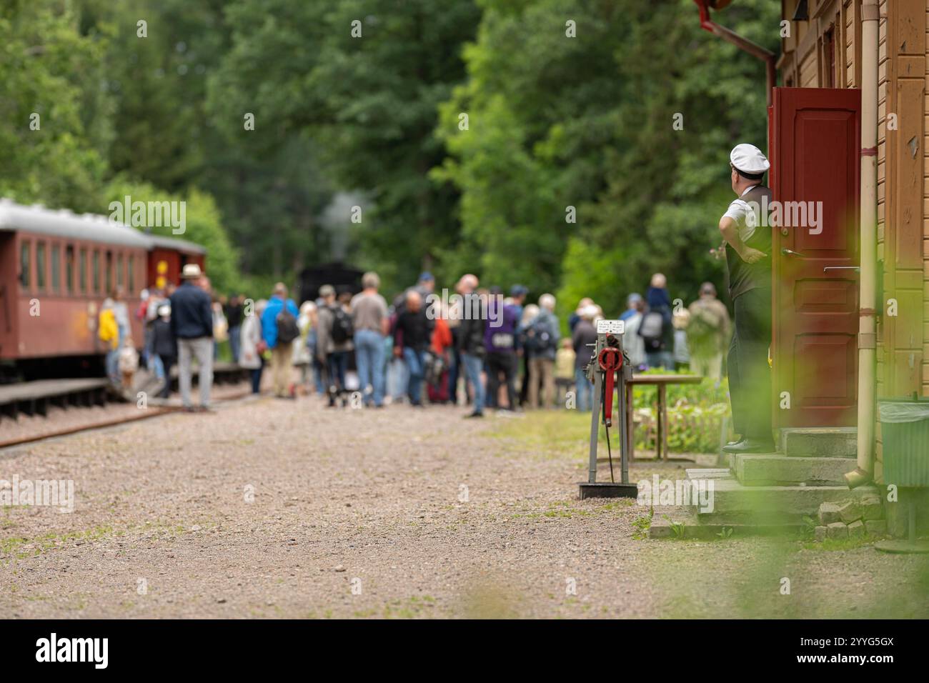 Railroad station master looking at passengers Stock Photo - Alamy