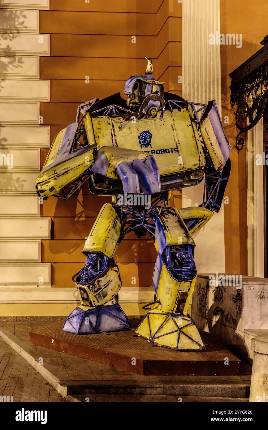 A robot is holding a box with the letters "H.D." on it. The robot is ...