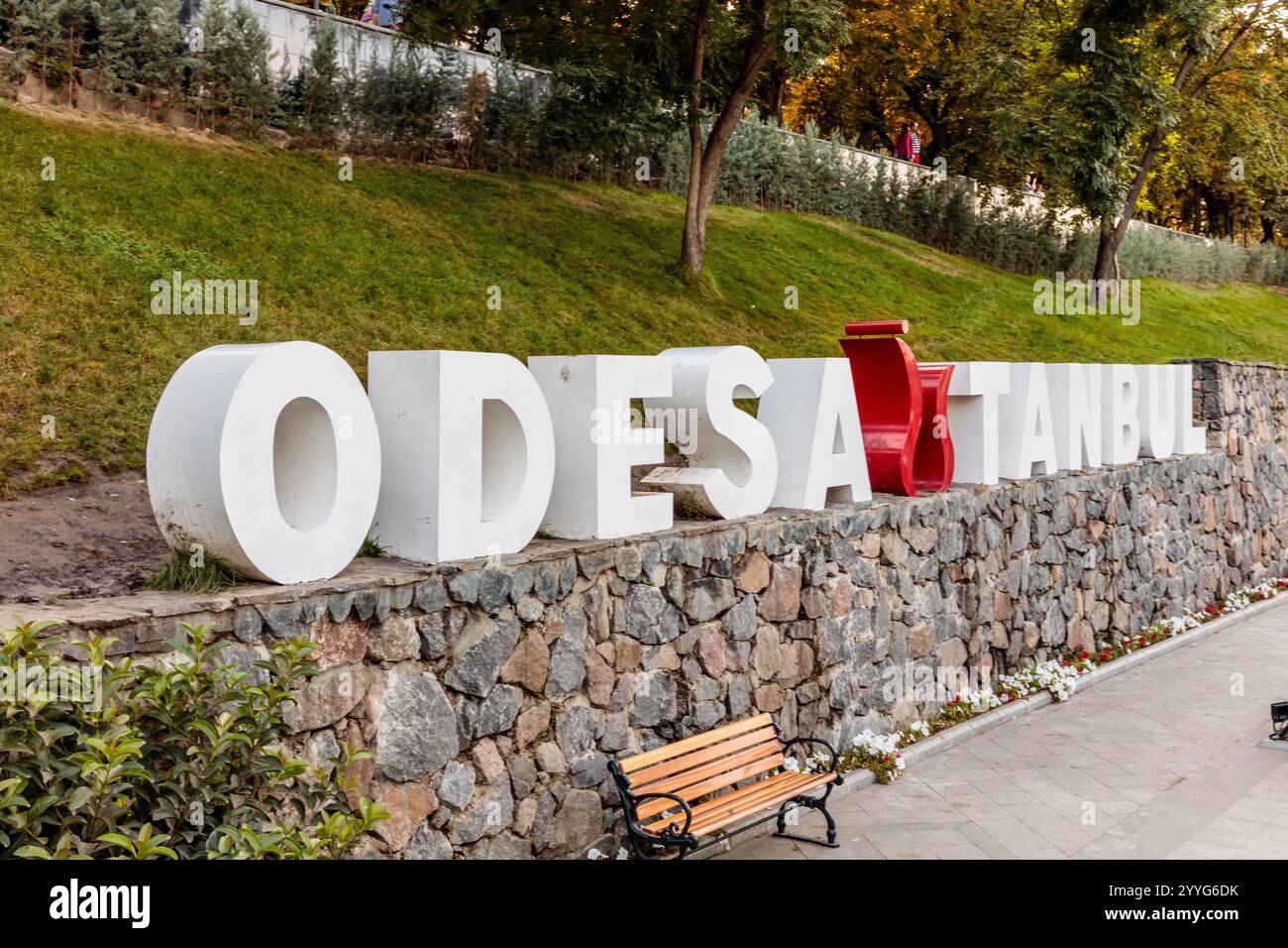 A large white sign with red letters that say ODESA TANBUL. The sign is ...