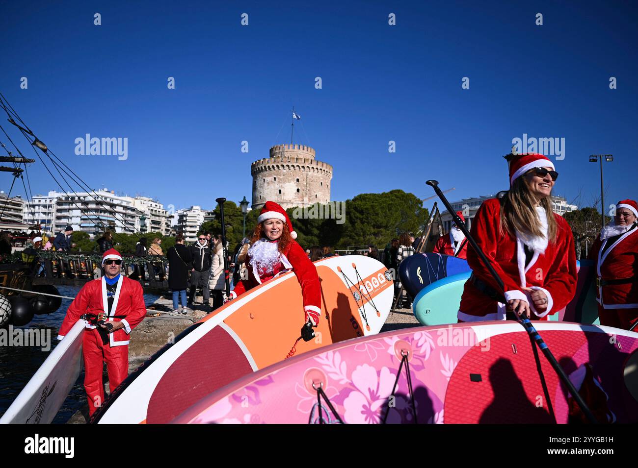 Participants wearing Santa Claus costumes, carry equipment for a Santa ...