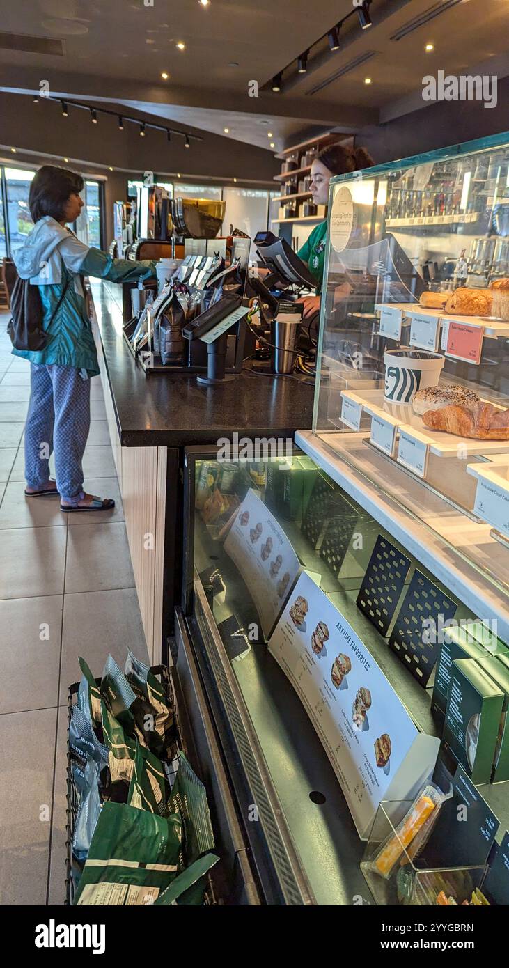 Starbucks Scene: Customer at Checkout with Displayed Pastries and Menu ...